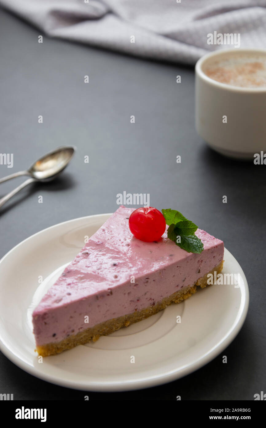 Cheesecake slice with berries and coffee cup, pink cheesecake isolated ...