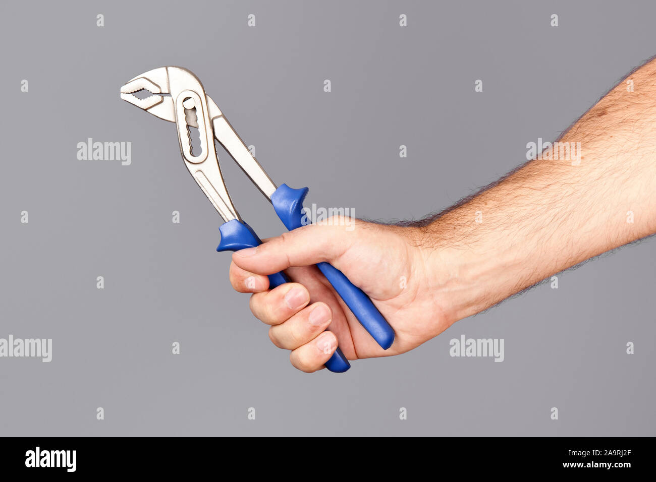An image of a man holding pliers Stock Photo - Alamy