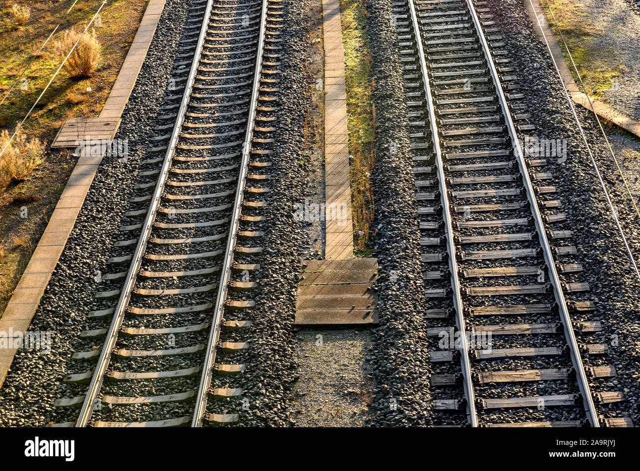 Modern European railway station at sunrise with rail tracks and trains ...
