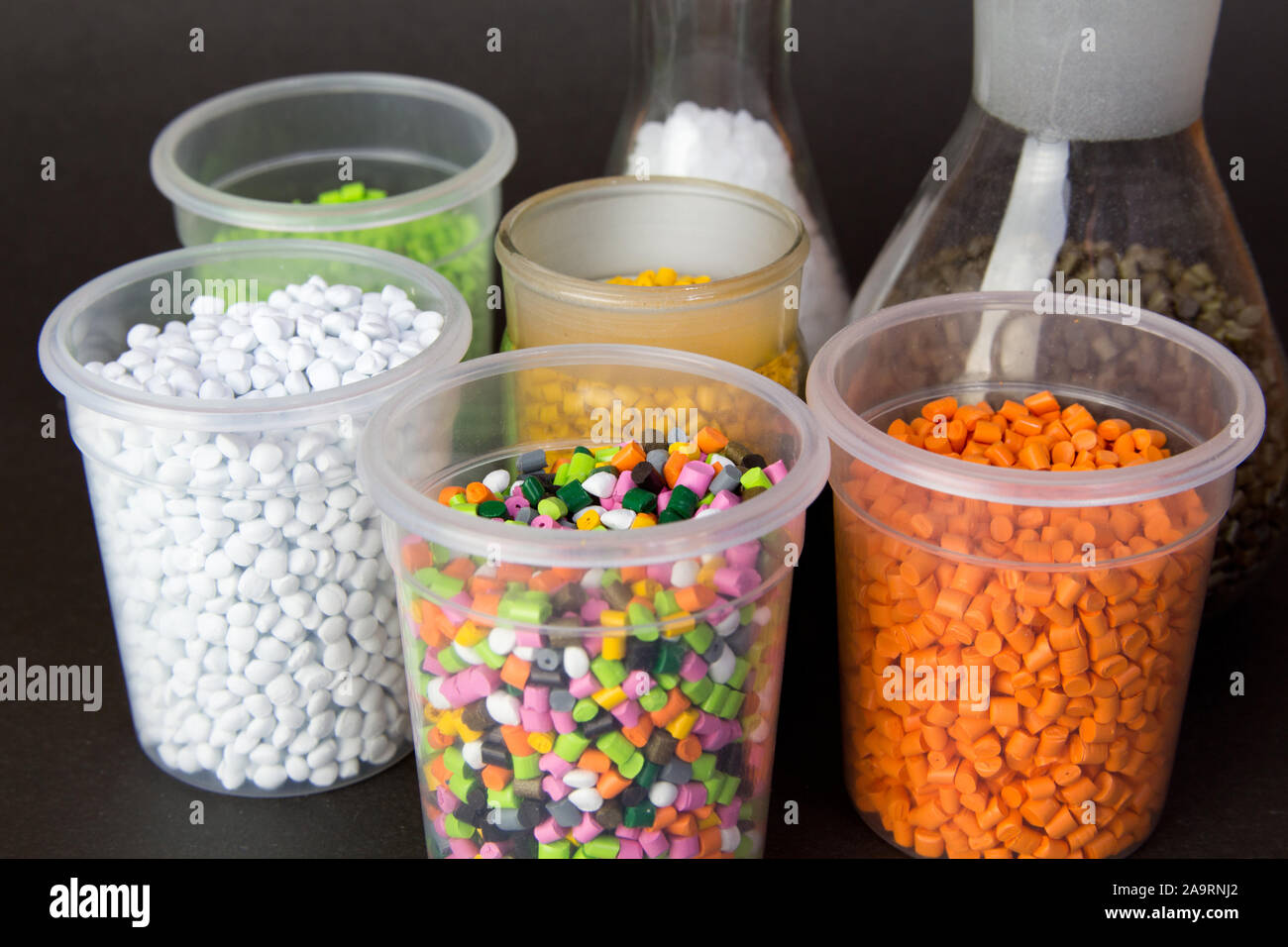 Plastic granules in a measuring container and test tubes in the ...