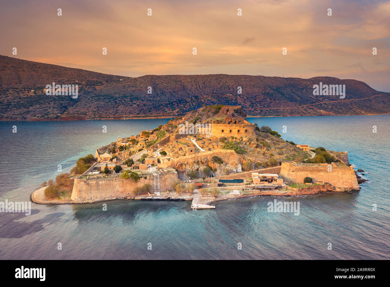 Aerial view of the island of Spinalonga with calm sea. Here were ...