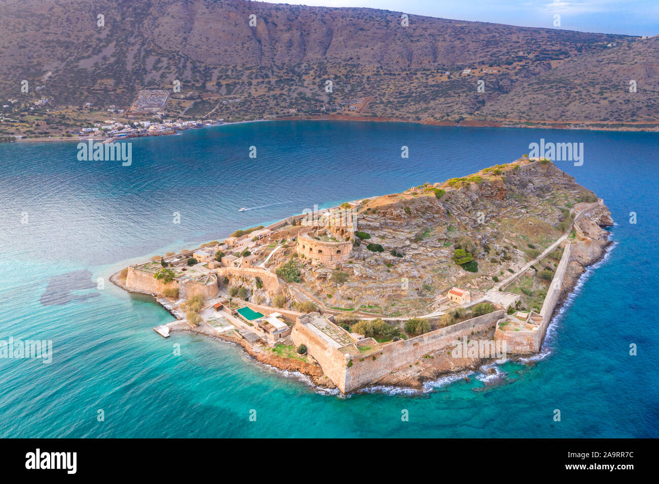 Aerial view of the island of Spinalonga with calm sea. Here were ...