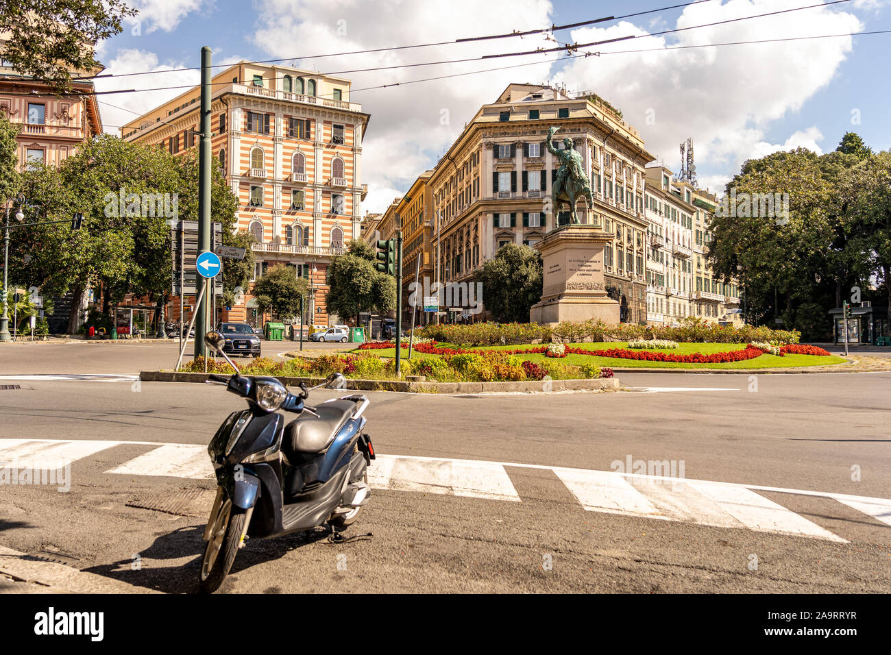 a scooter (vespa) standing in front of a roundaboutn in genua, italy ...