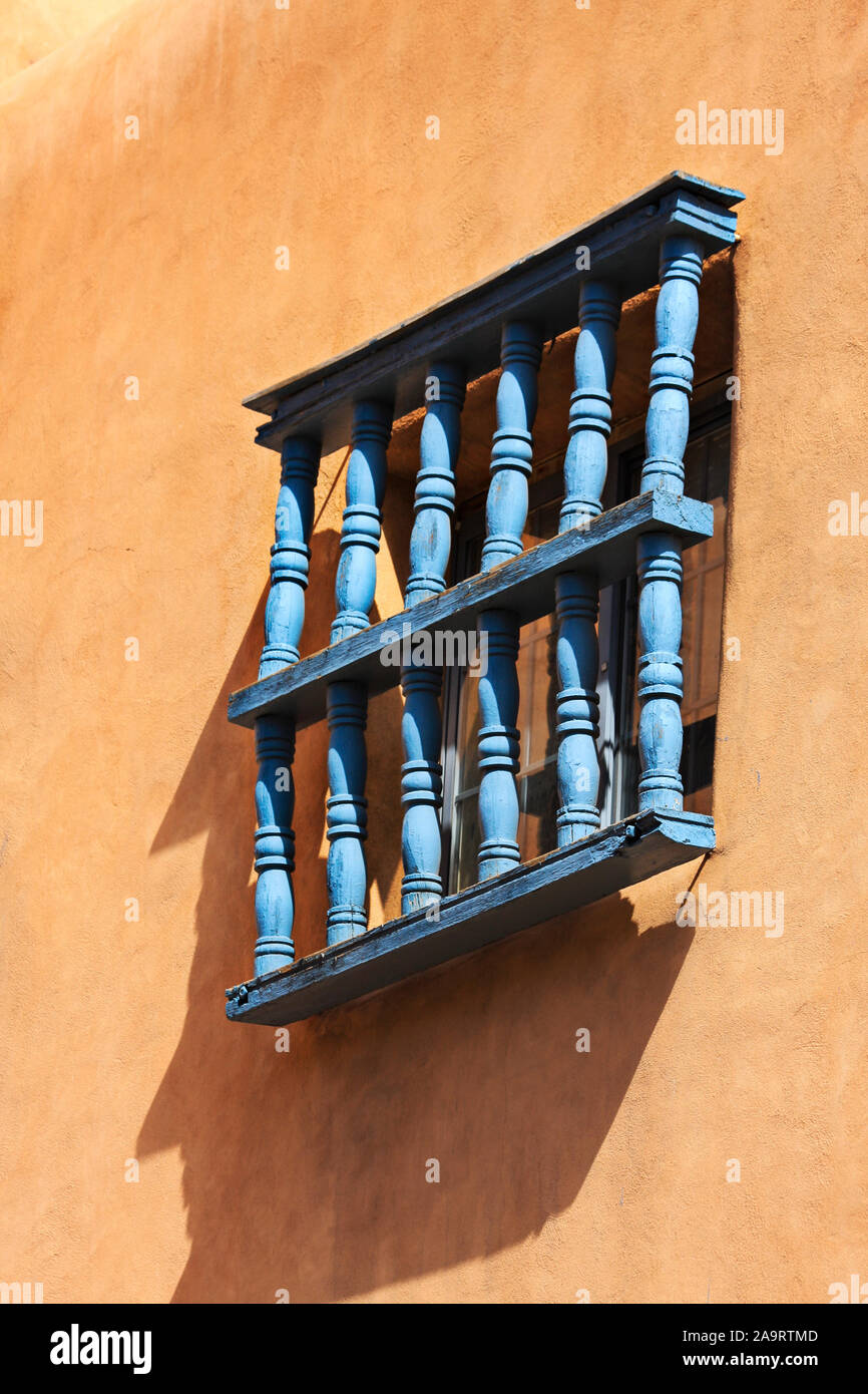 Blue timber or wood baluster or balustrade covers window of adobe ...