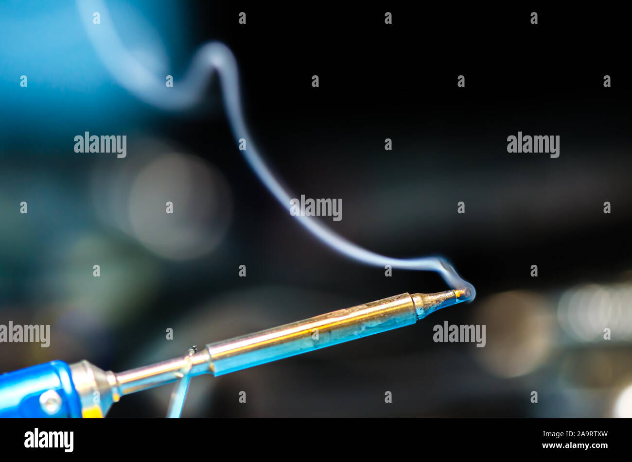 soldering iron with smoke on a black background. Electrical ...