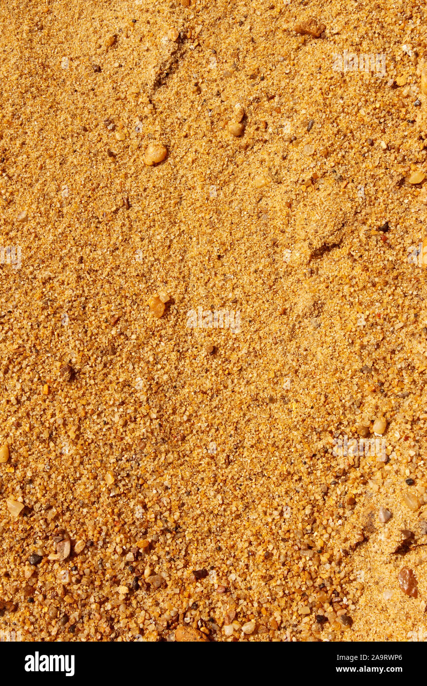 Yellow sand with small colored stones as a texture Stock Photo - Alamy