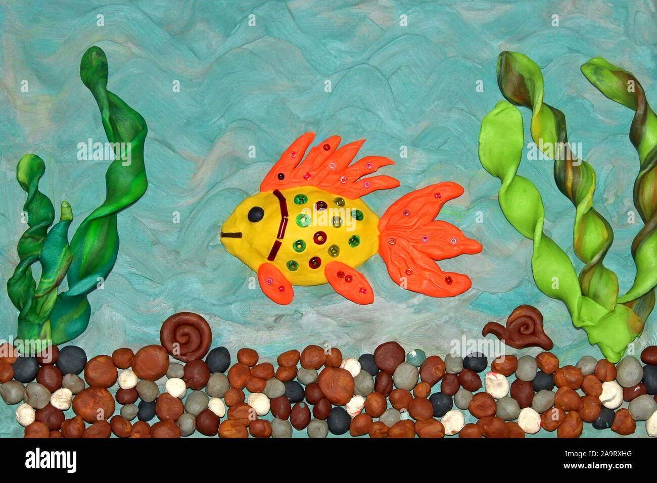 Bright yellow fish floating between seaweed at the sea bottom, handmade ...