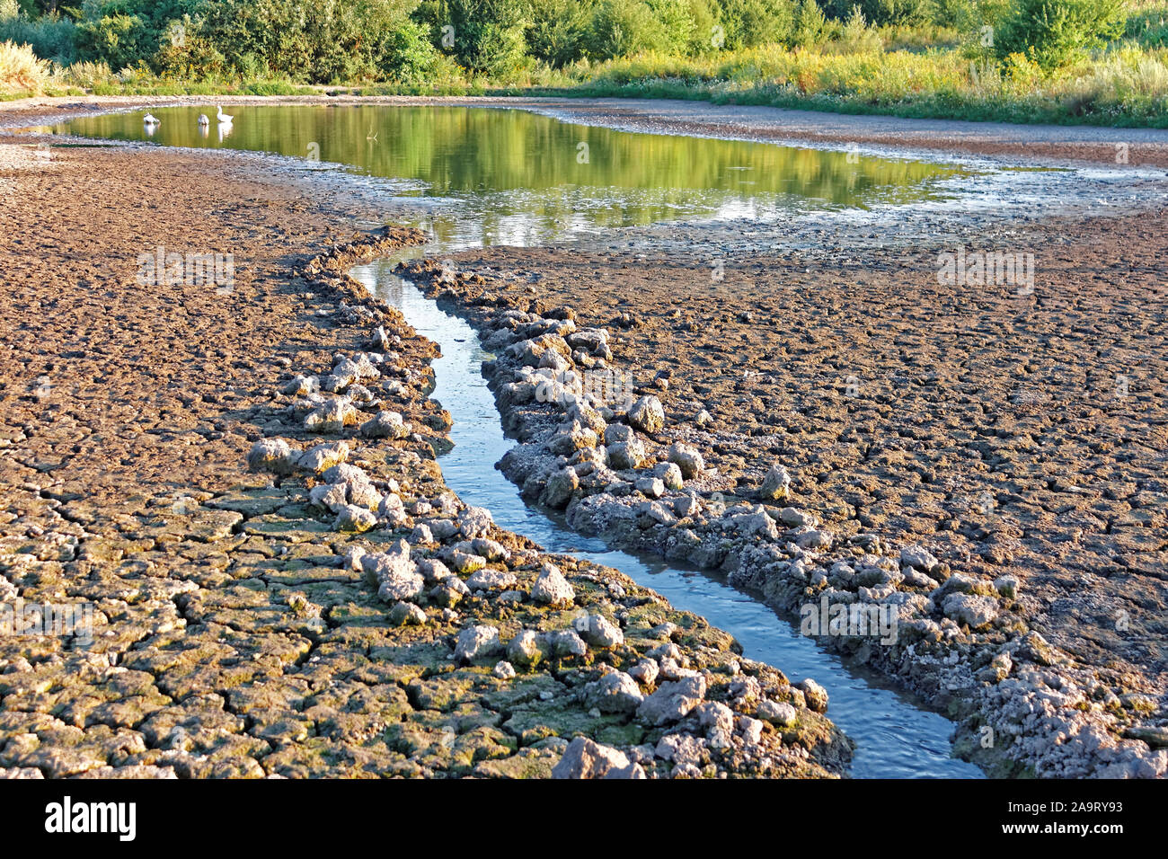 Water stream in artificially dug canal flows into the pond shrinking ...