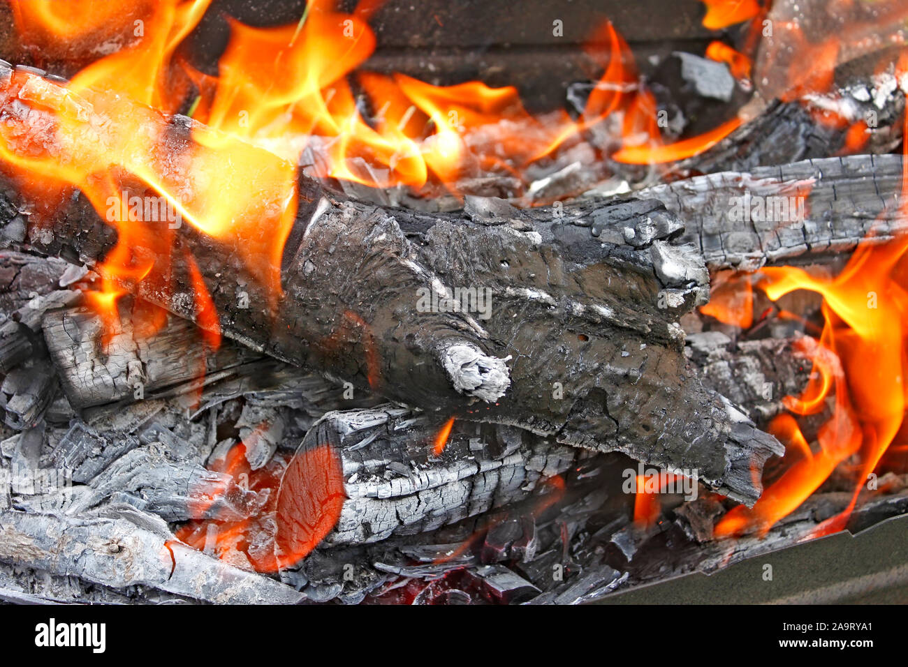 Burning firewood with ashes and flames close-up Stock Photo - Alamy