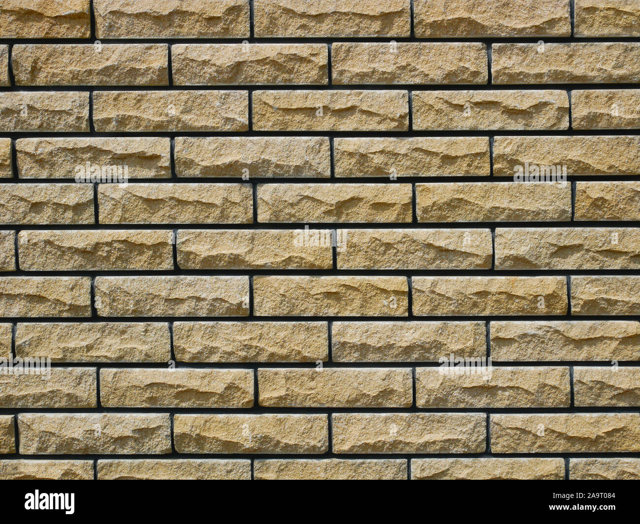 Brick stone wall background in warm hues Stock Photo - Alamy