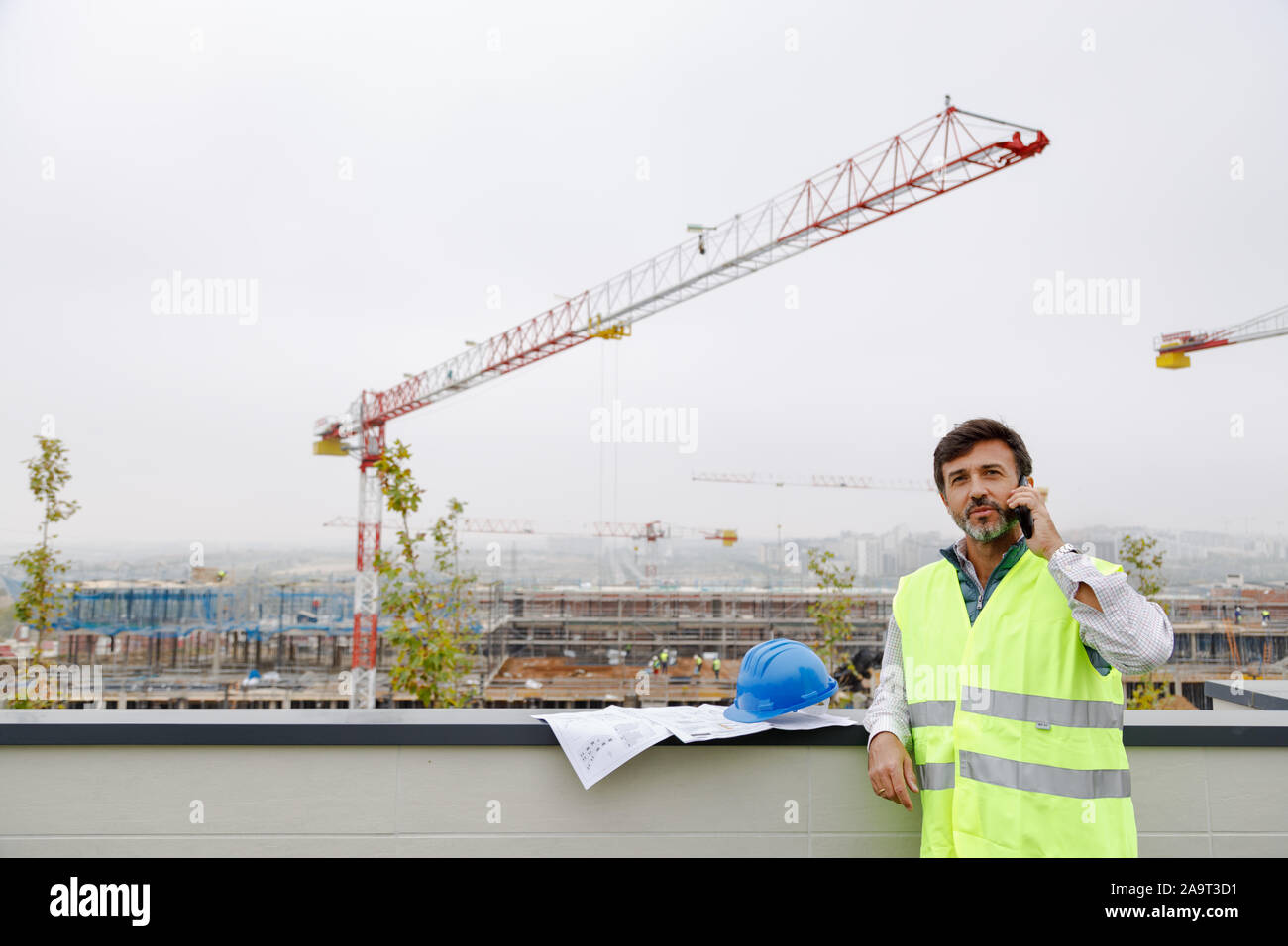 Engineer talking on the phone while working on the construction of luxury homes Stock Photo - Alamy