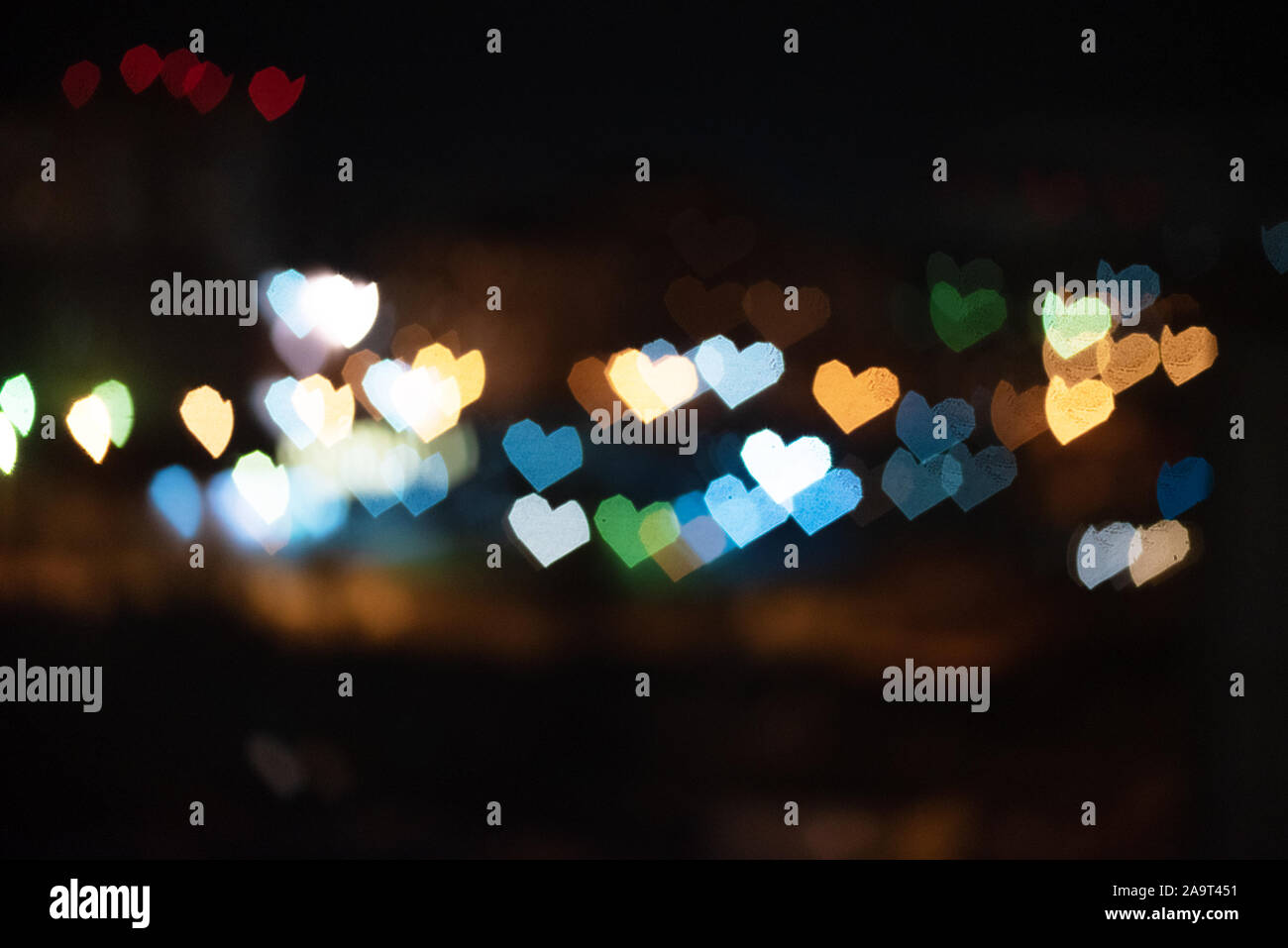 Blurred lights of night city in heart shape form abstract background ...