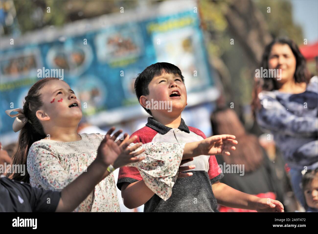 Hispanic Latin Mexican kids, boys and girls, chasing bubbles from fair ...
