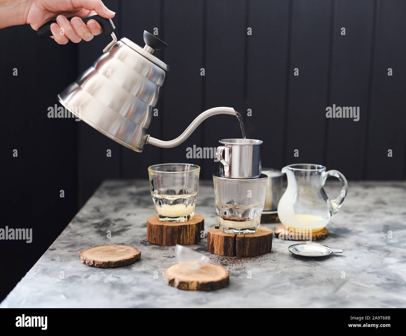 Making pour over Vietnamese milk coffee. Woman hand pouring water from ...