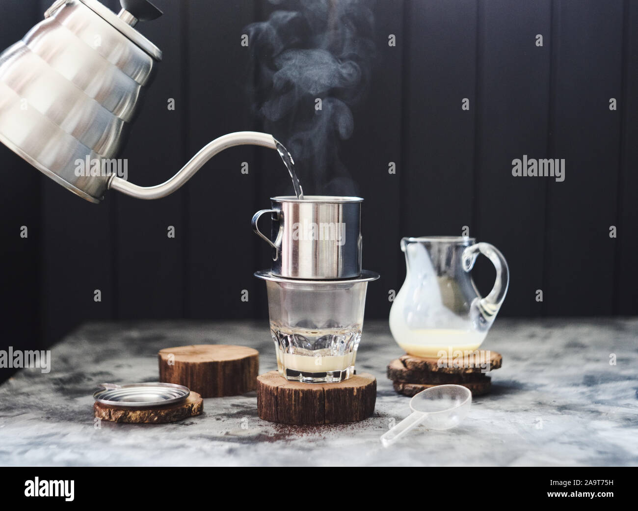 Making Vietnamese coffee with condensed milk. Pouring hot water from ...