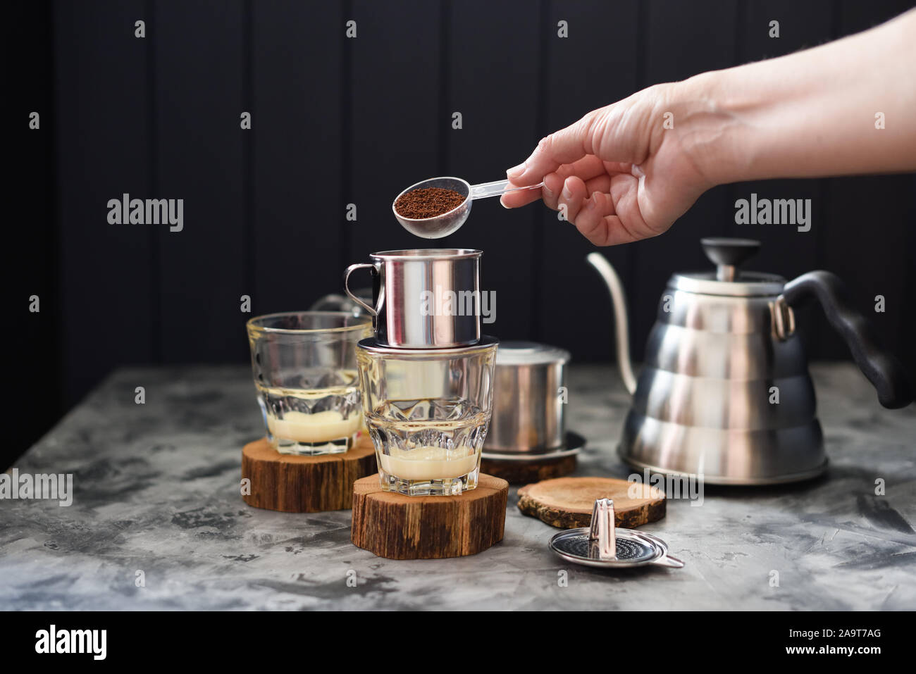 Making pour over coffee with condensed milk Vietnamese style. Woman ...