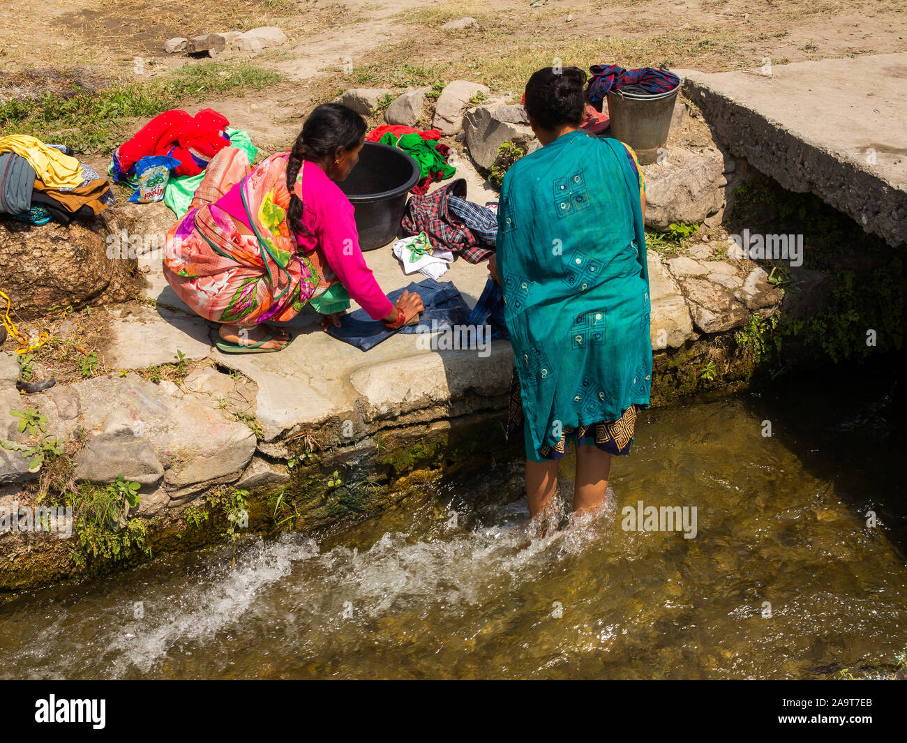 Indian woman washing clothes at the crystal clear water canal at ...