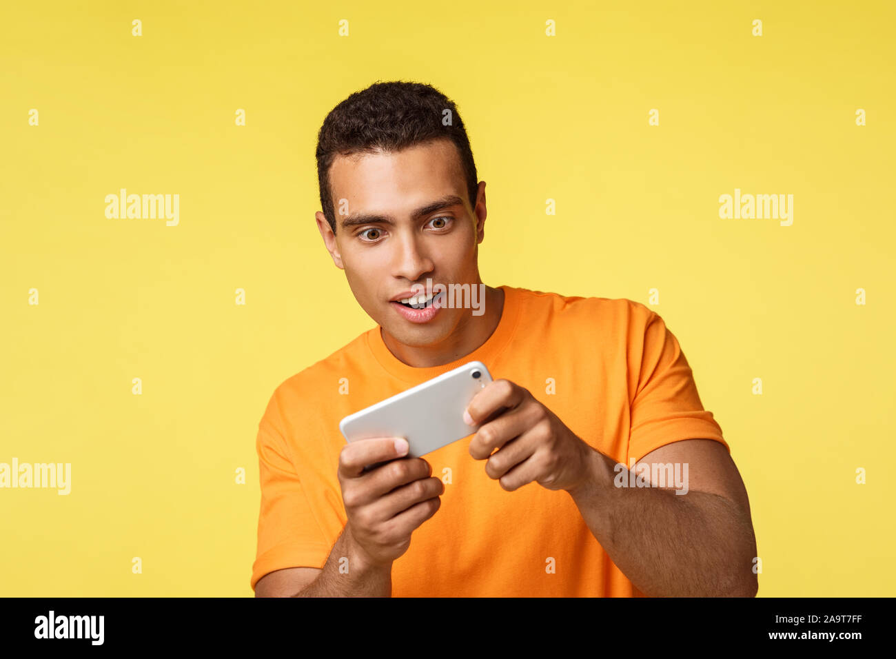 Excited handsome young male student waste time playing cool new game ...