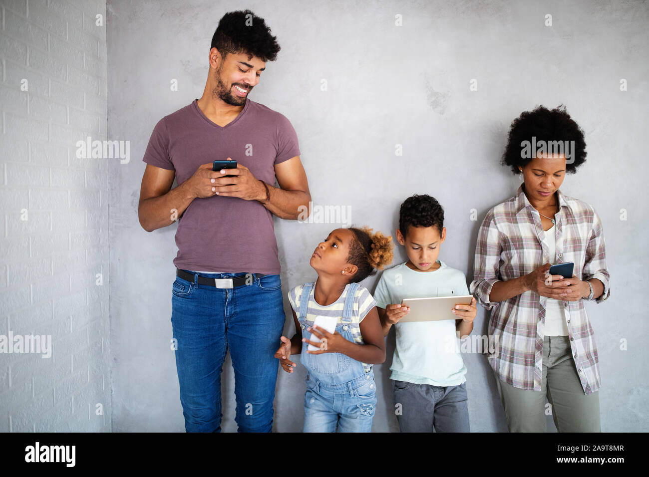 Happy african american family using technical devices, phone. tablet ...