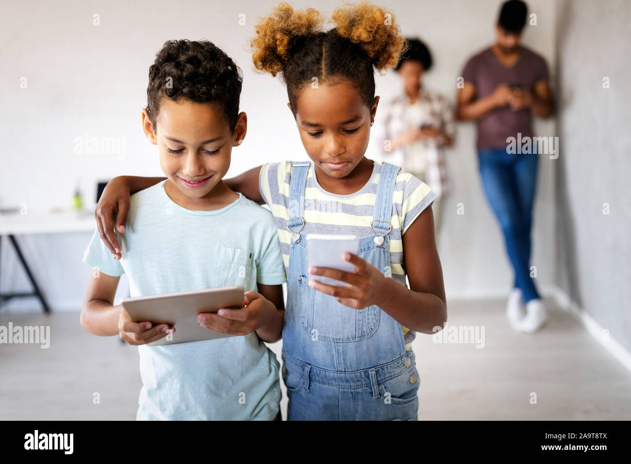 Happy african family using digital devices, tablet, smartphone ...