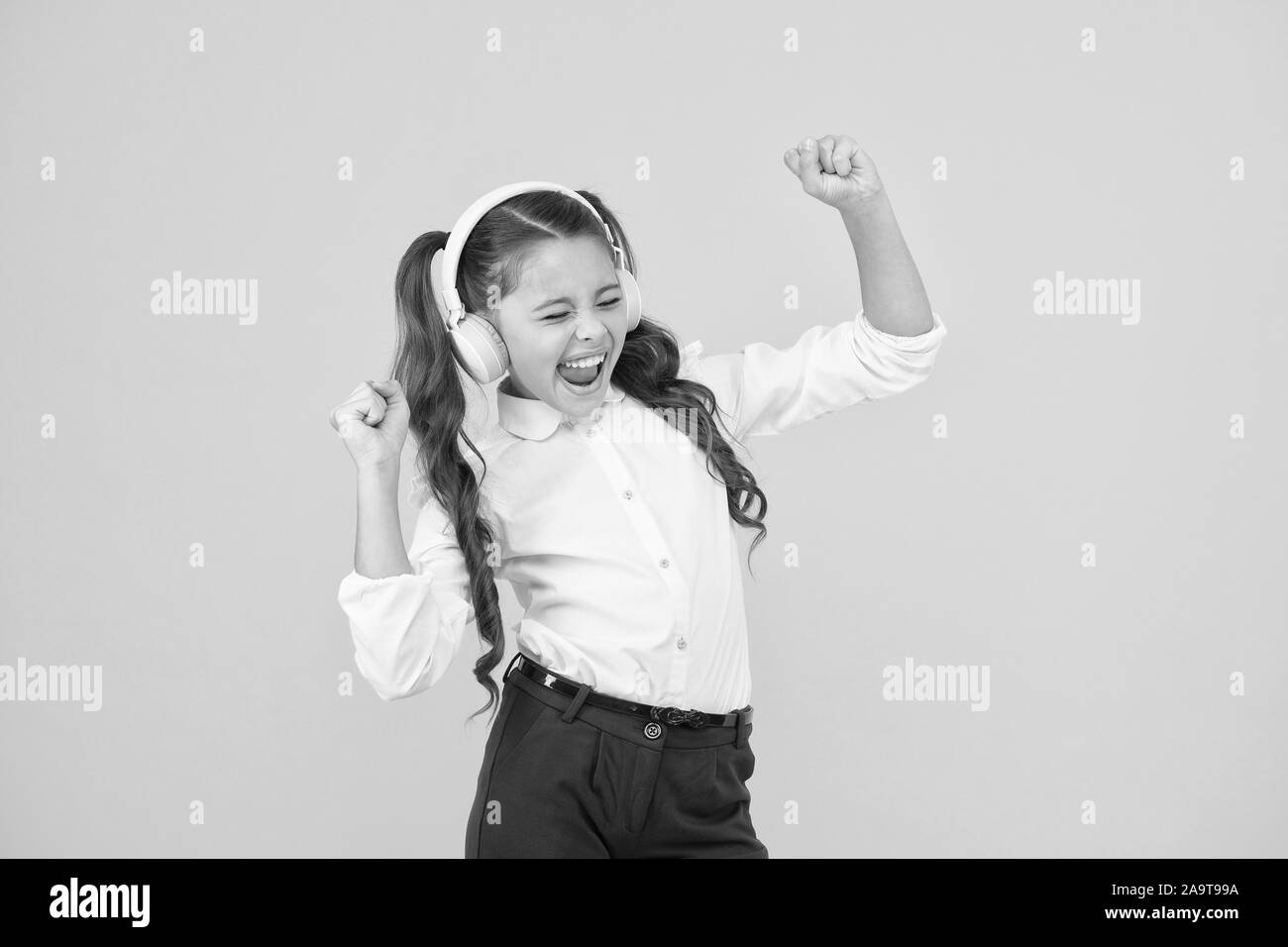 Singing in tune. Cute small child taking her singing lessons on yellow ...