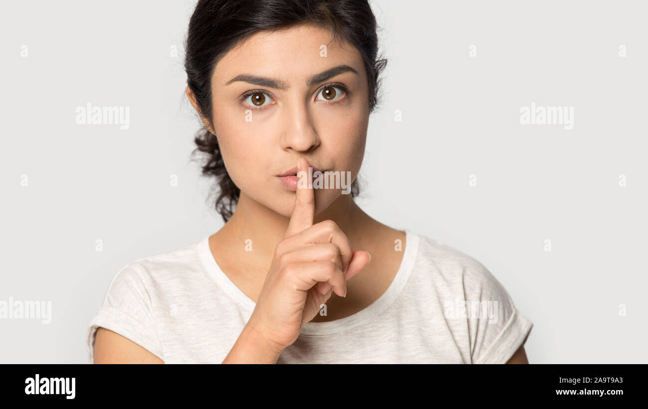 Headshot portrait serious Indian woman showing hush gesture close up ...