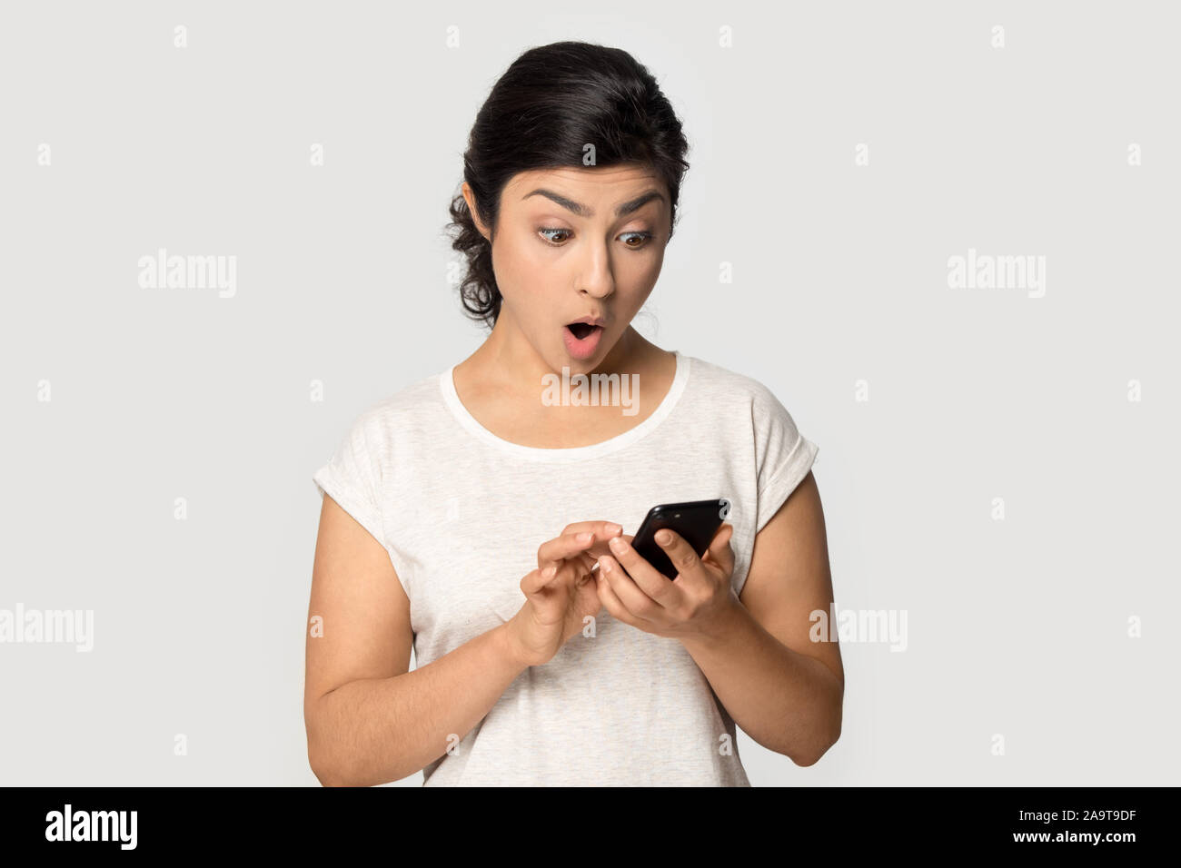 Shocked Indian girl using phone, reading unexpected news close up Stock ...