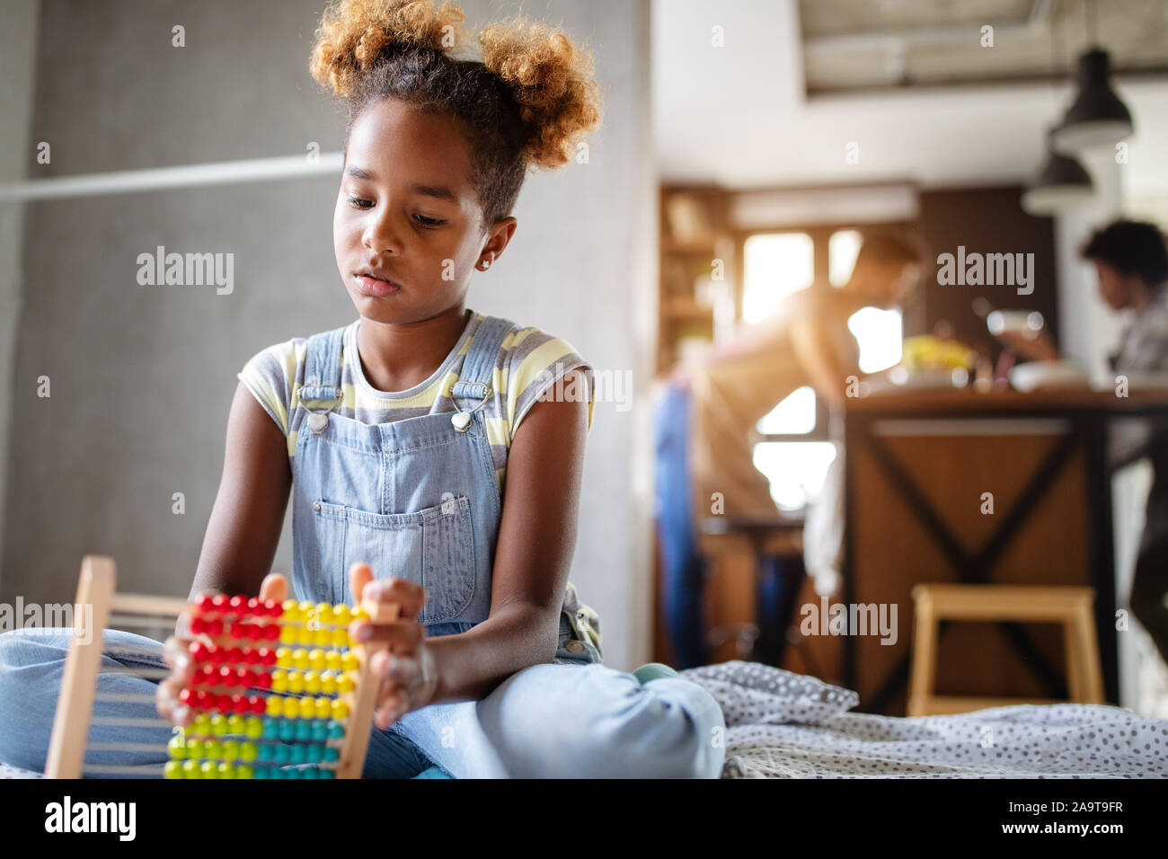 Happy african american kid girl learn to count at home with abacus ...