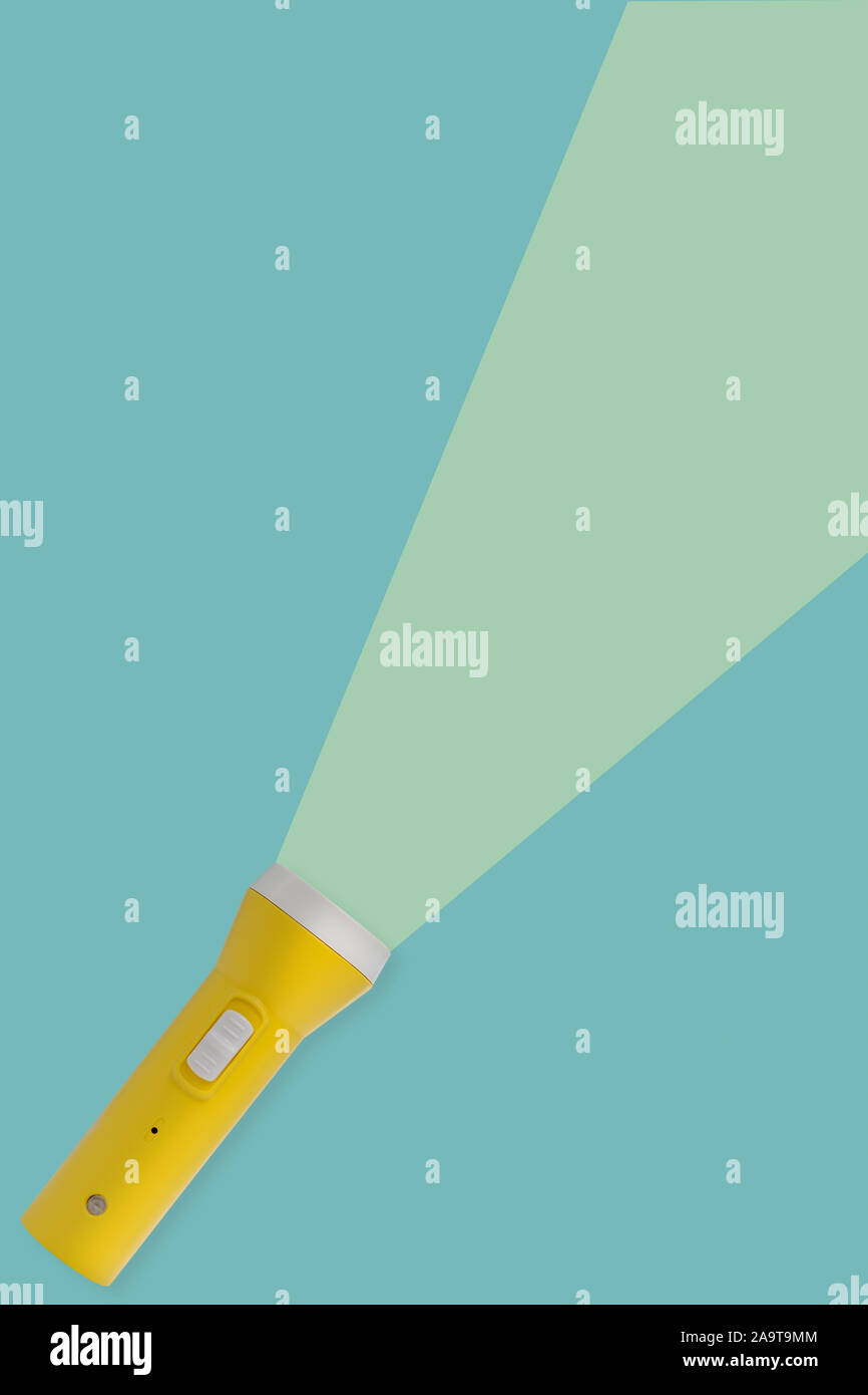 Yellow flashlight on a blue background with copy space. concept of ...