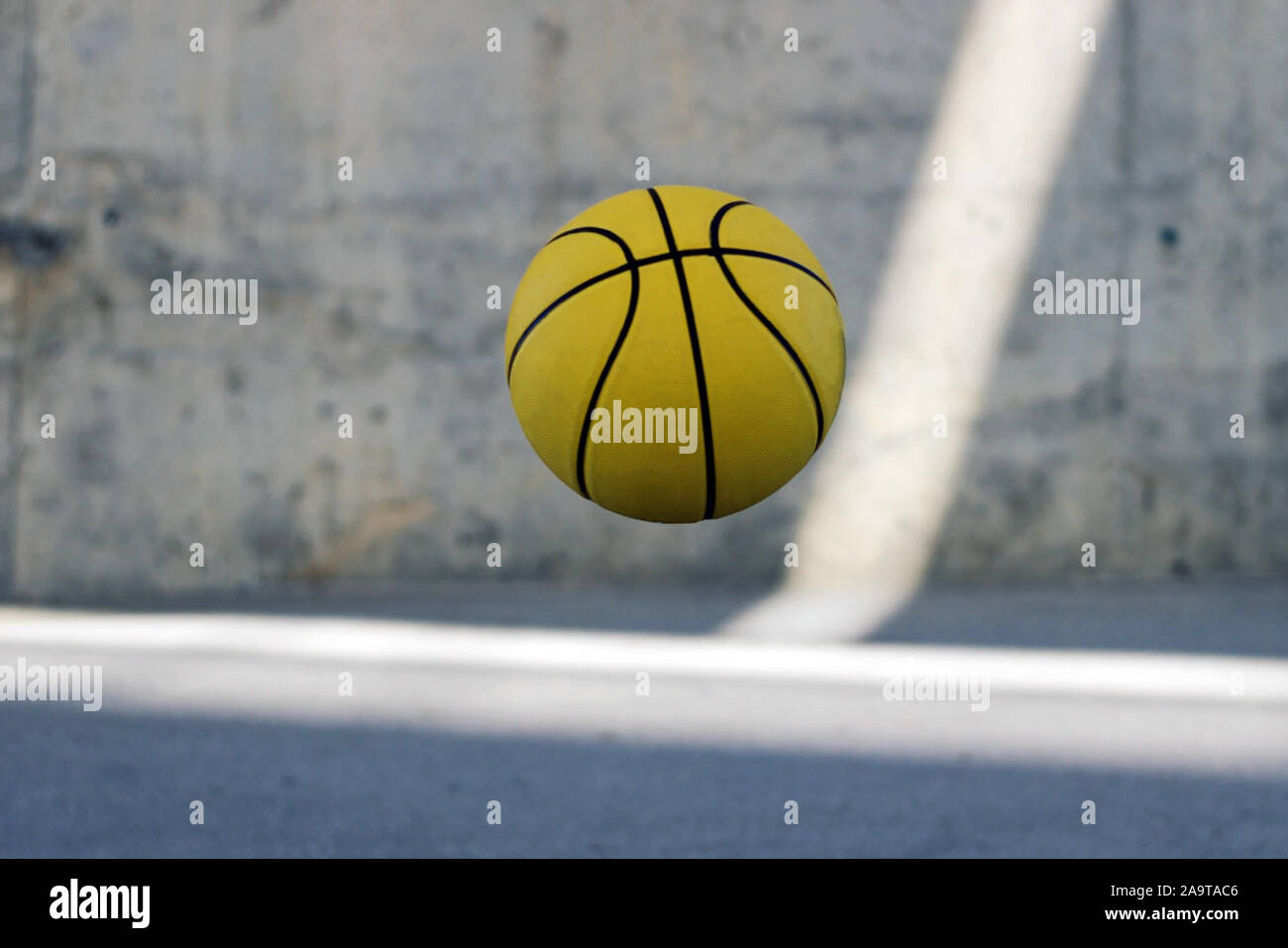 Yellow basketball in the air in an urban court. Basketball concept ...