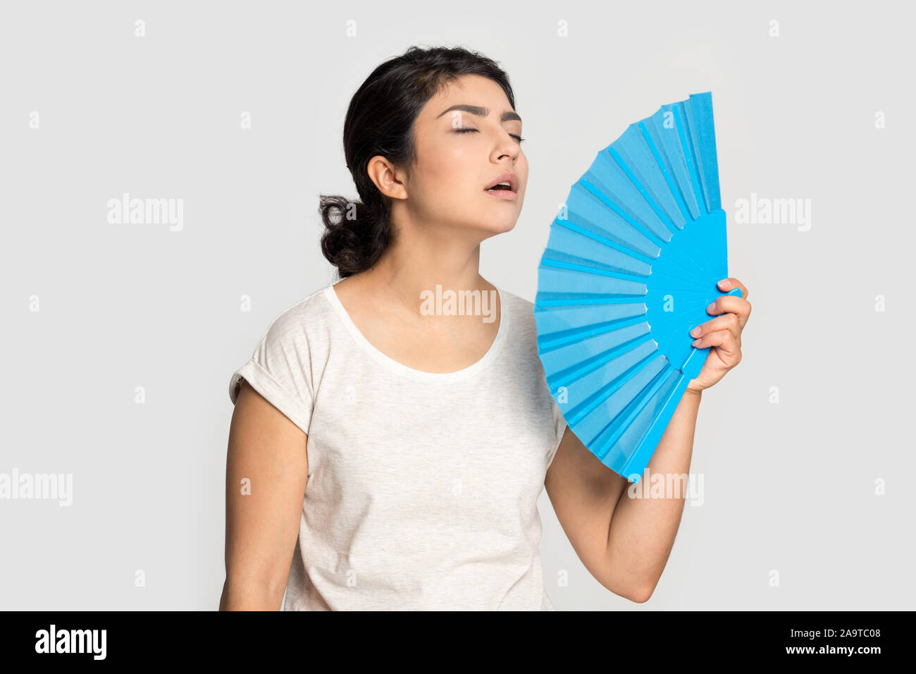 Tired exhausted Indian girl waving fan, suffering from heat Stock Photo ...