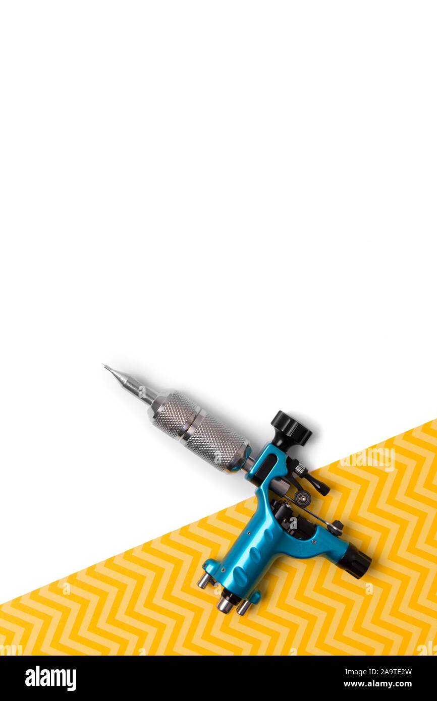 Blue tattoo machine on creative white and yellow background Stock Photo ...