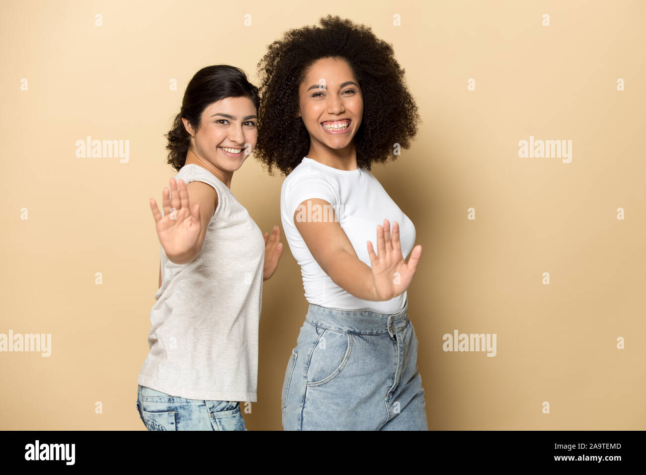 Smiling beautiful diverse girls dancing, standing with arms ...
