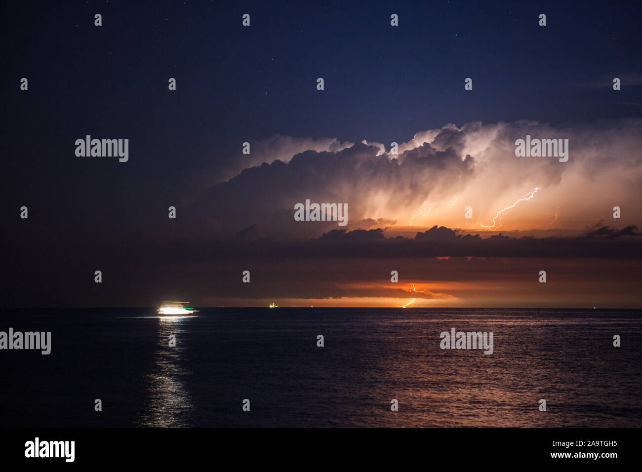 lightning above the sea and blurred boat Stock Photo - Alamy