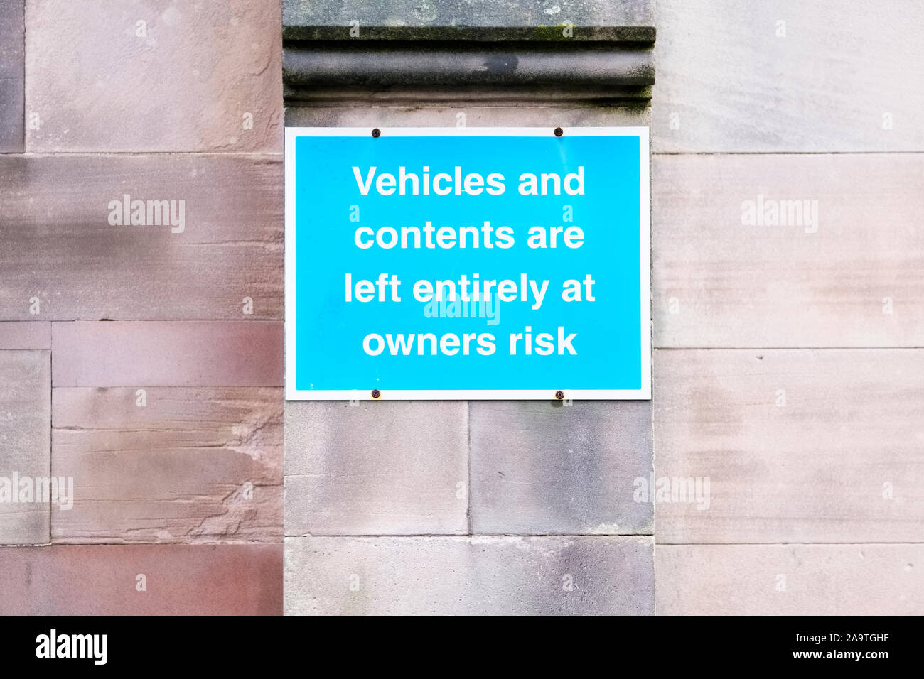 Vehicles and contents left at owners risk sign at car park Stock Photo ...