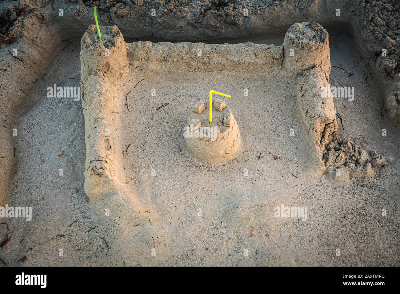 A sand castle with coloured plastic straws planted in the towers Stock ...