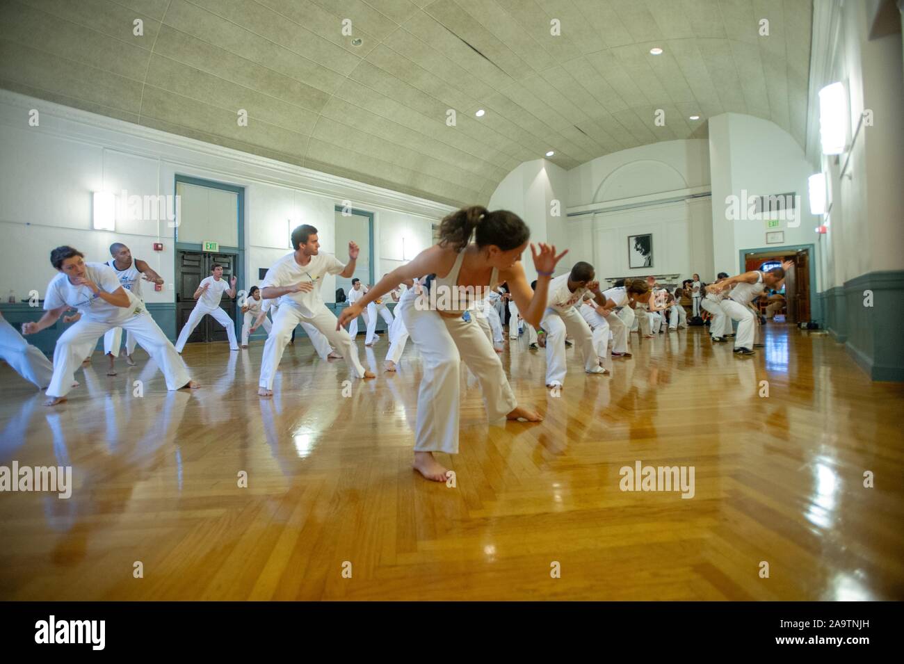 A group of students practice capoeira in a studio space at the Johns ...