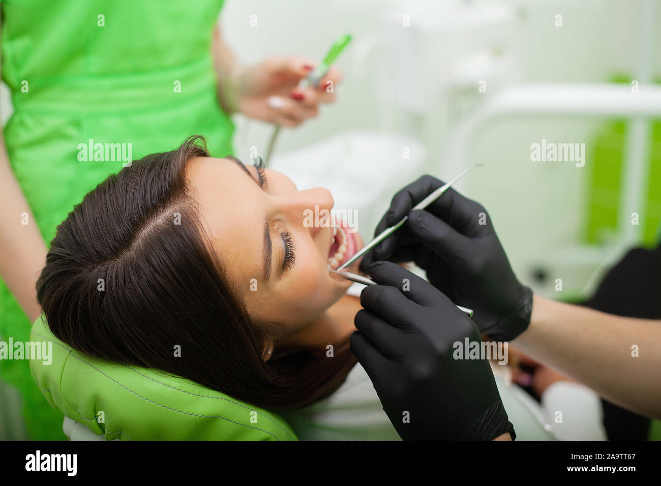 The dentist man are treating teeth to client in dental office Stock ...