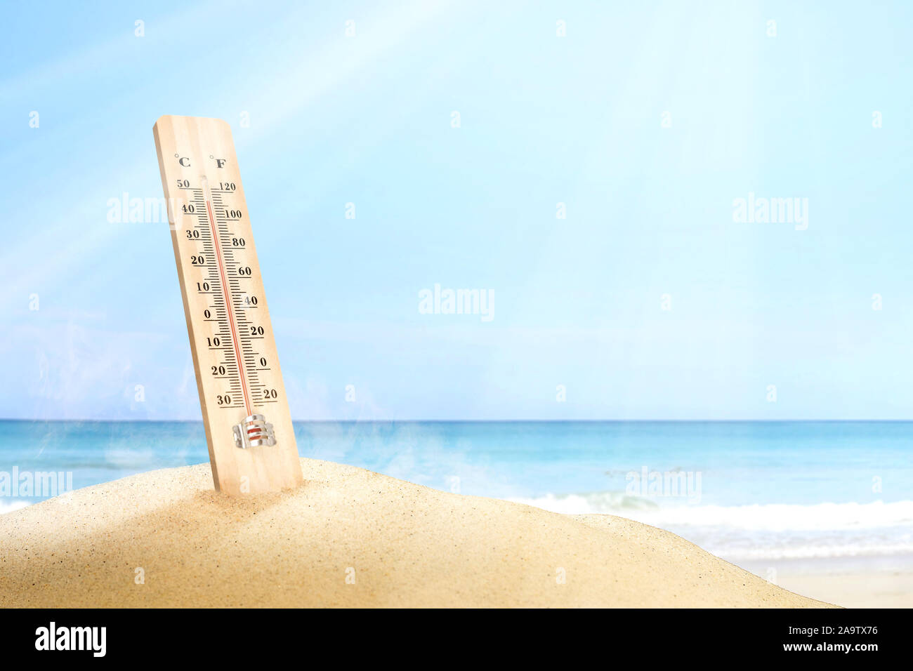 Thermometer measuring the temperature on the beach with a blue sky ...