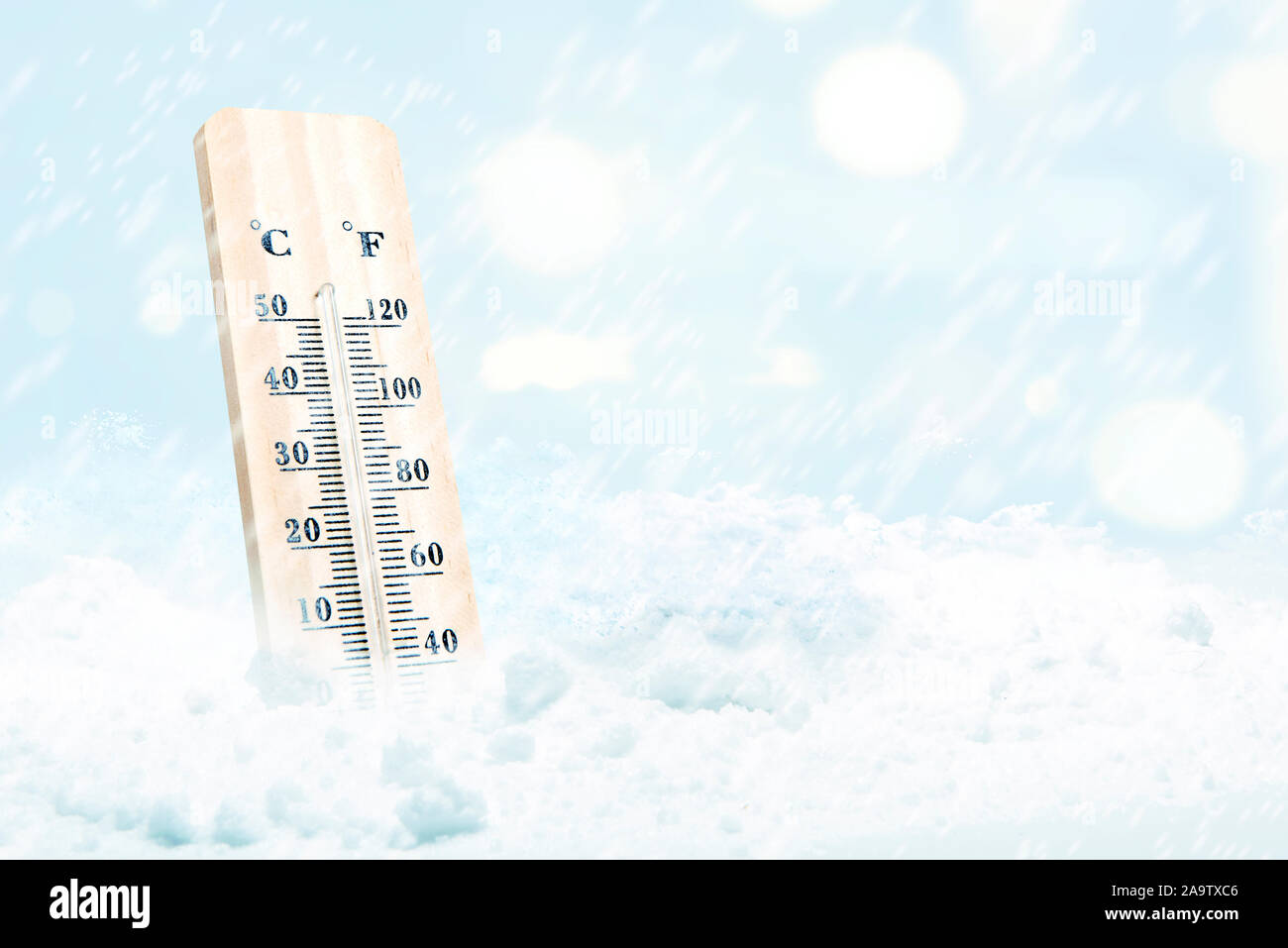 Wooden thermometer with the low temperature at winter with snowfall ...