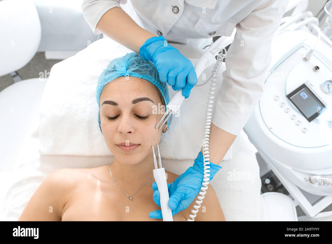 Portrait of a young beautiful girl face microcurrent therapy procedure ...