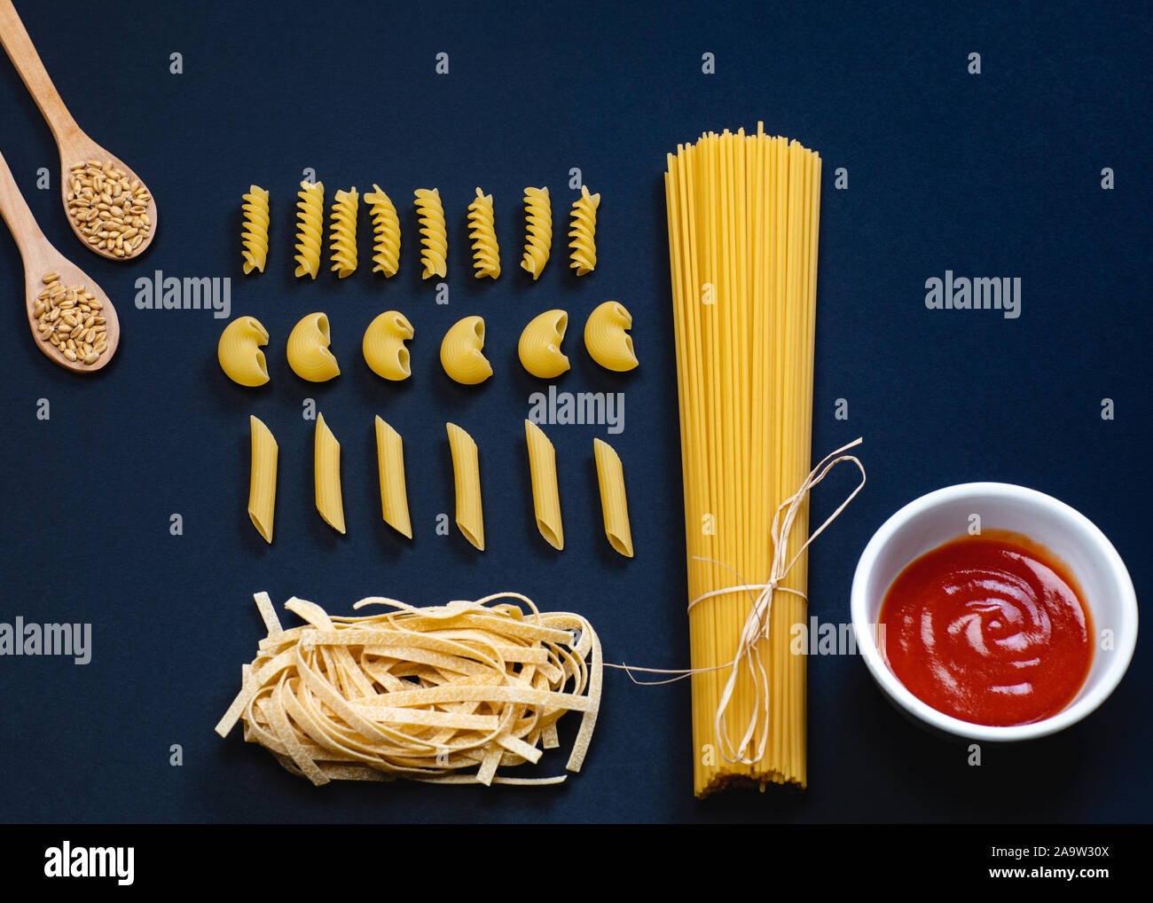 Different shapes of pasta and spaghetti on black background Stock Photo ...