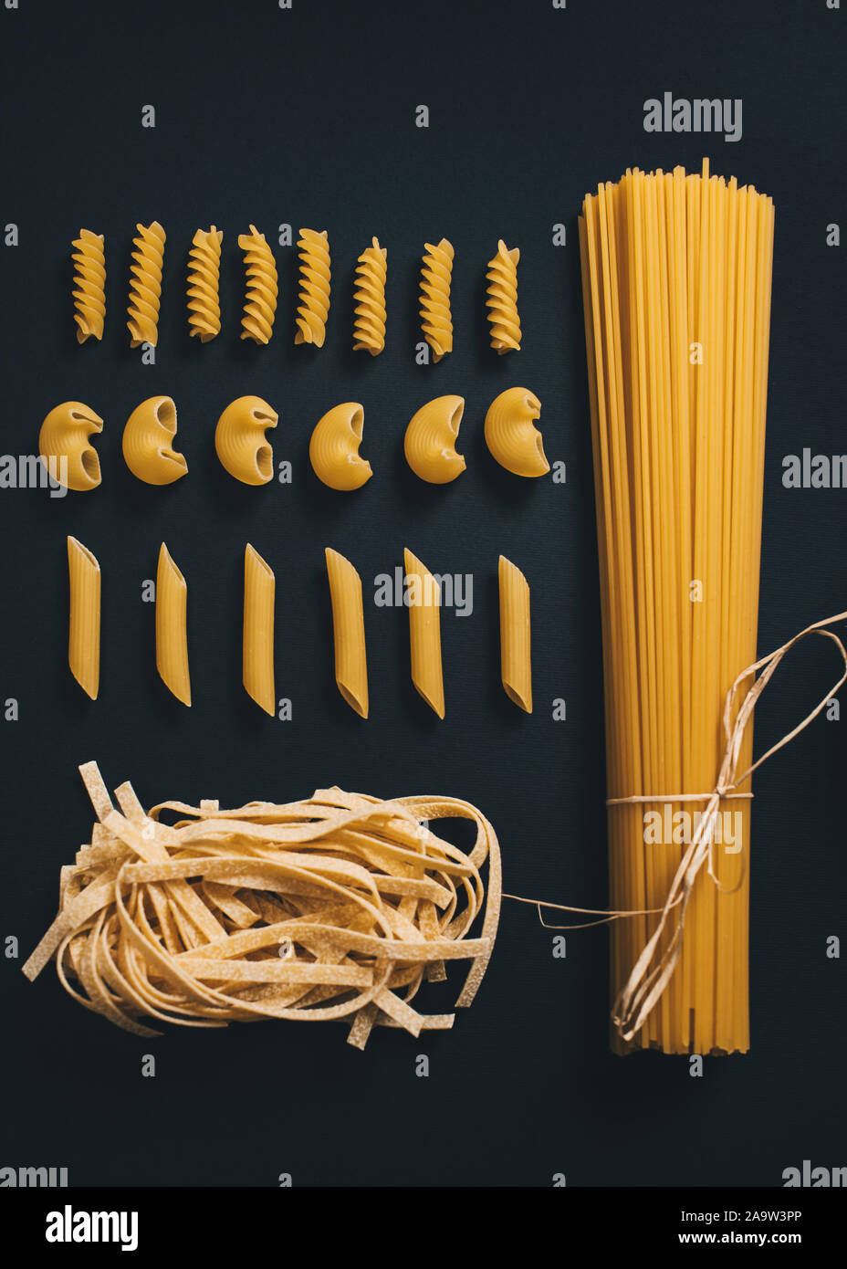 Different shapes of pasta and spaghetti on black background Stock Photo ...
