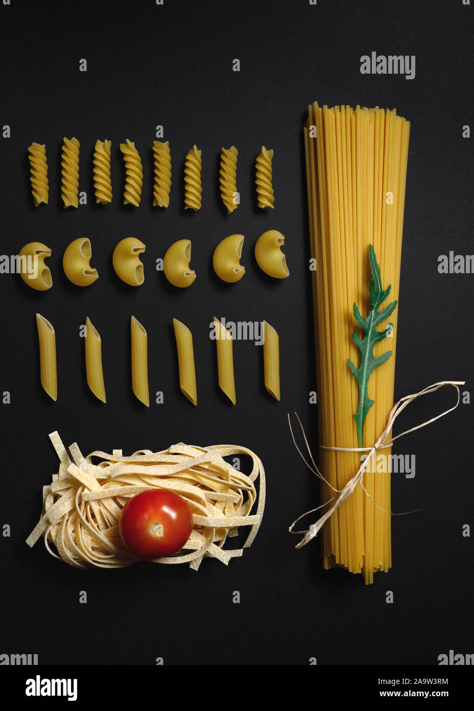 Different shapes of pasta and spaghetti on black background Stock Photo ...