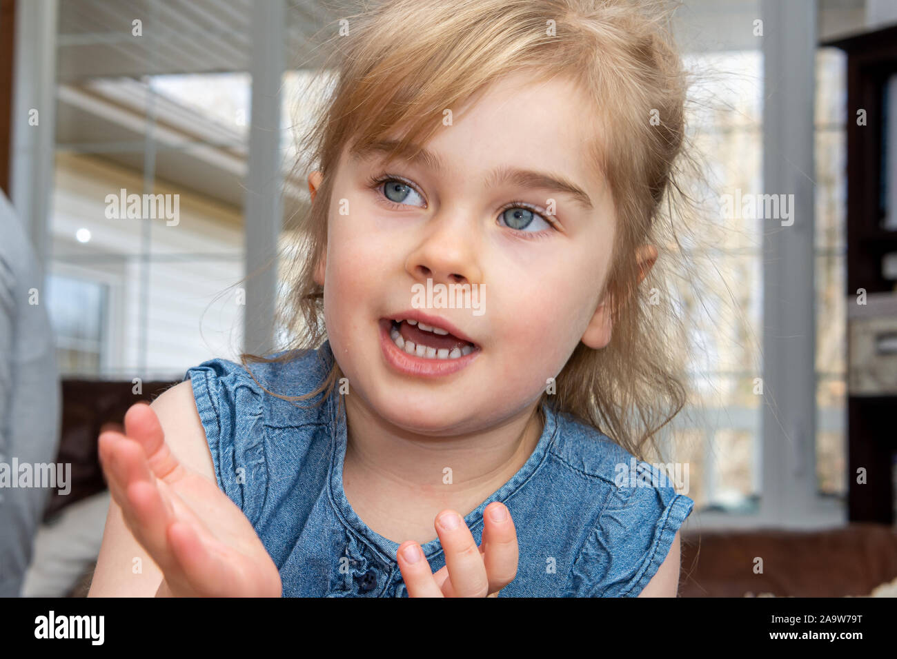 A very cute, adorable, blue eyed young girl with a very expressive face ...