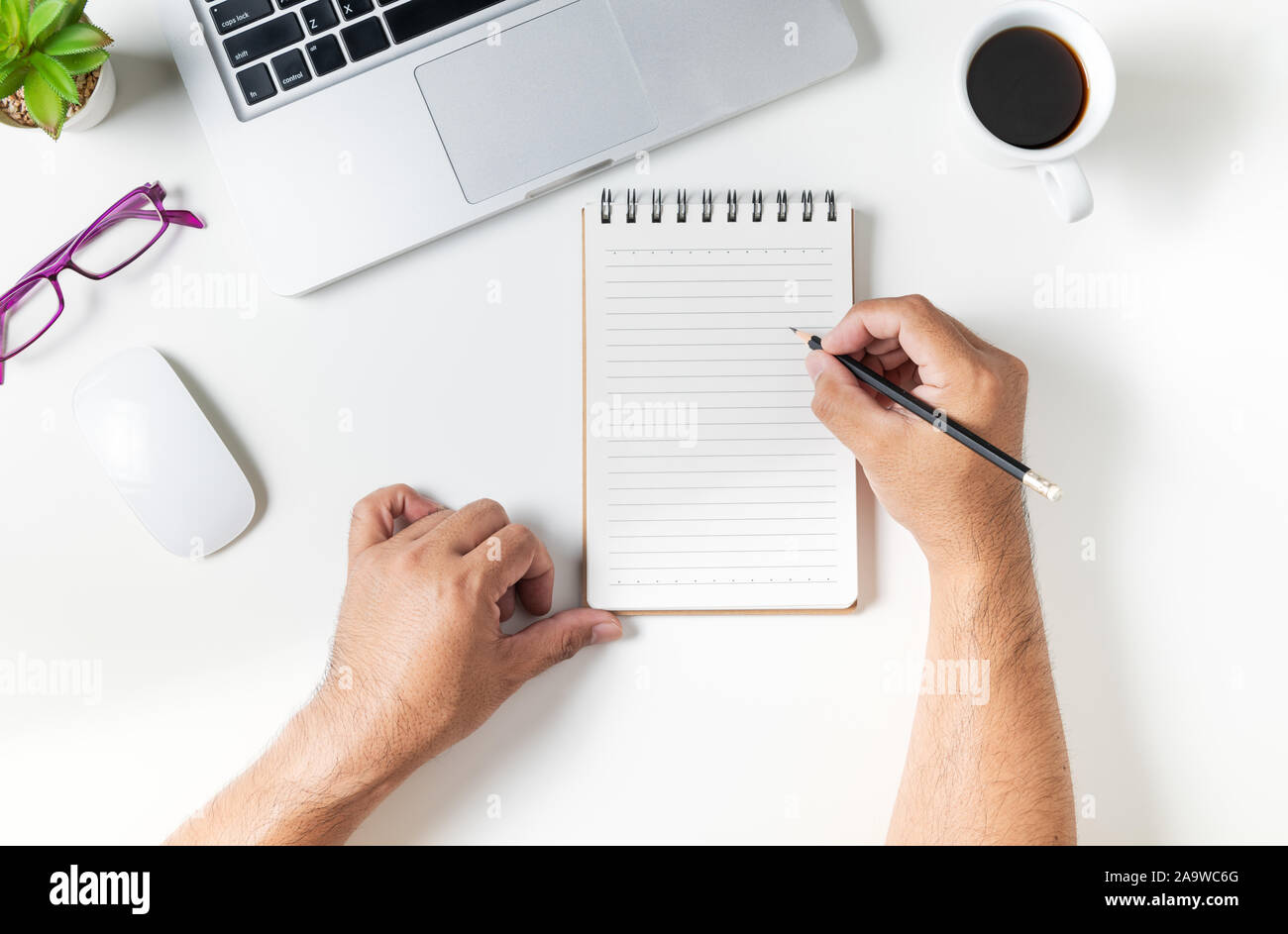White office desk table with hand man writing something on blank ...