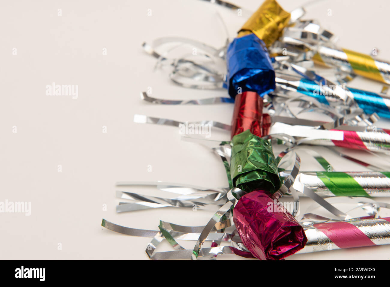 Isolated blue, pink, green, yellow and red party blowers on white ...