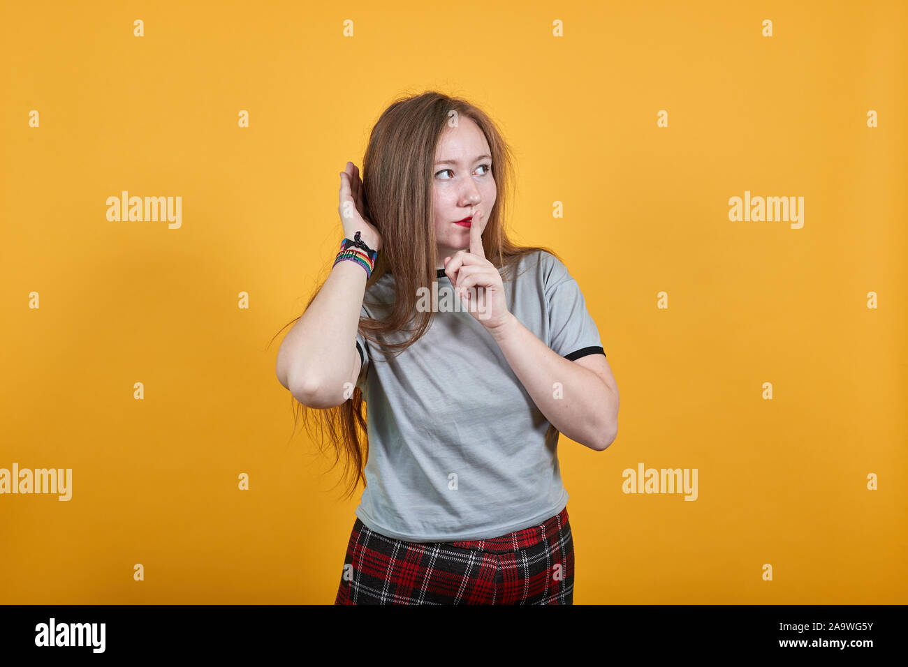 Cute woman putting hand prop up on mouth, shh gesture, keeping hand on ...
