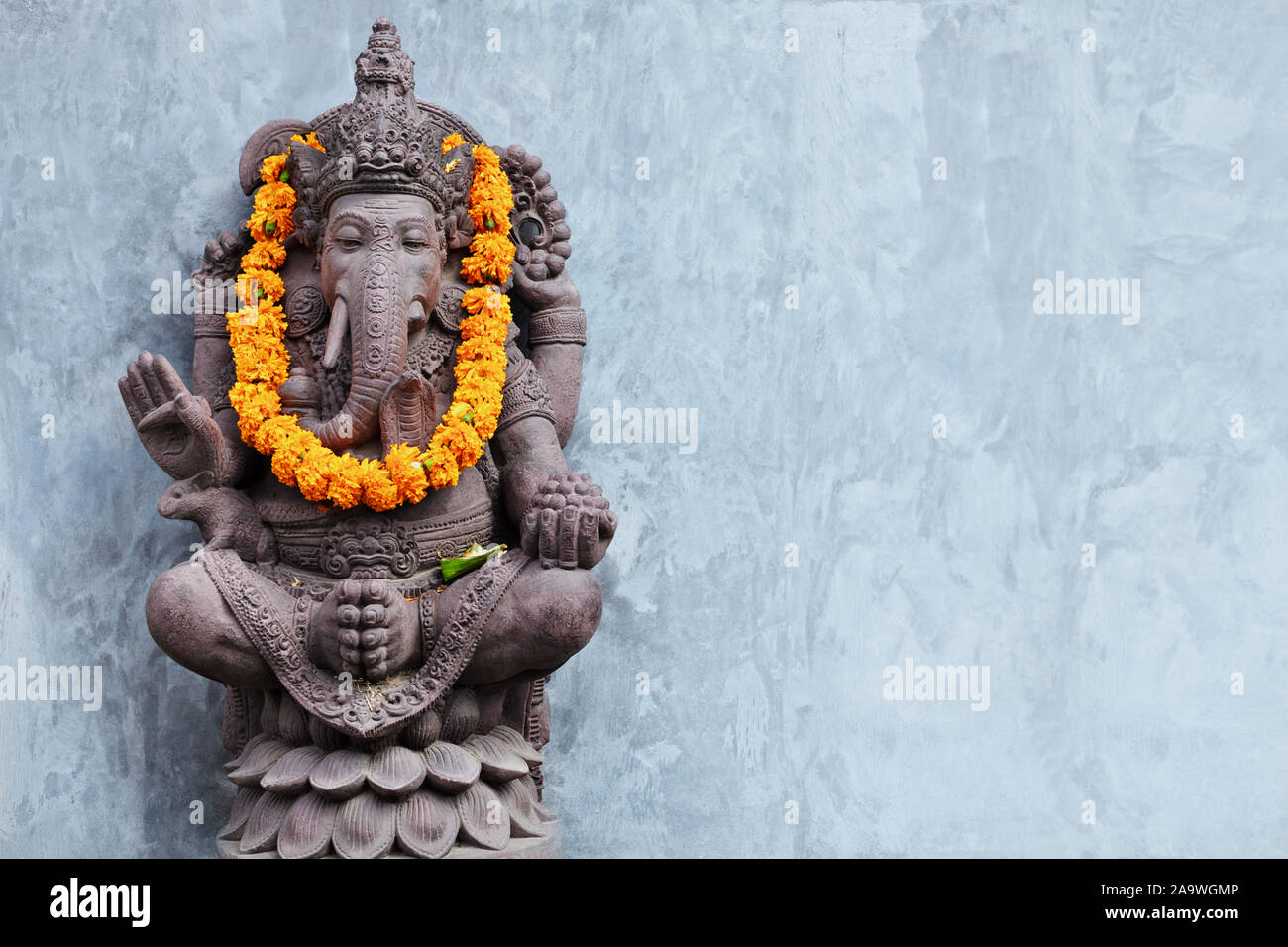 Ganesha sitting in meditating yoga pose in front of hindu temple ...