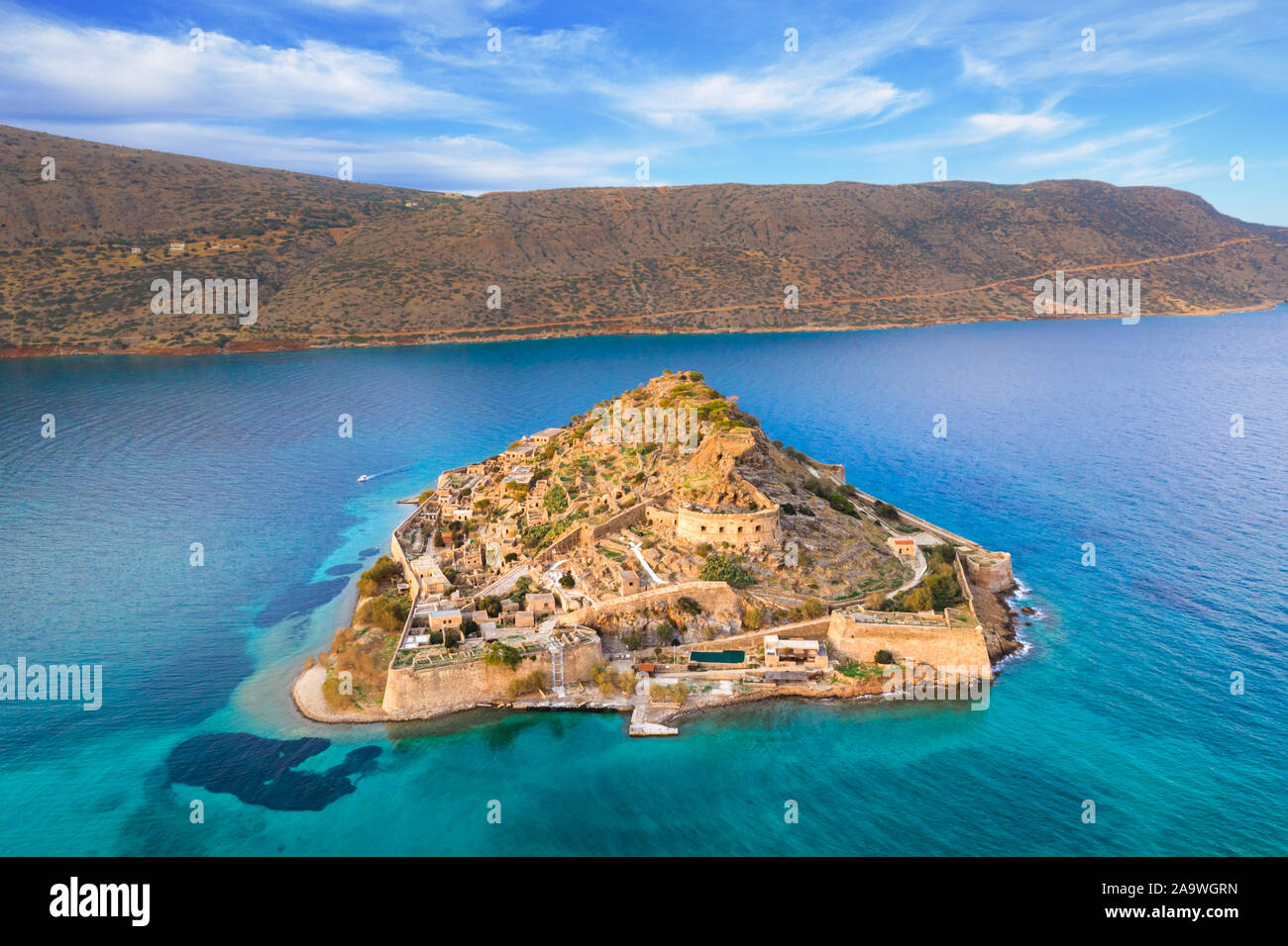 Aerial view of the island of Spinalonga with calm sea. Here were ...